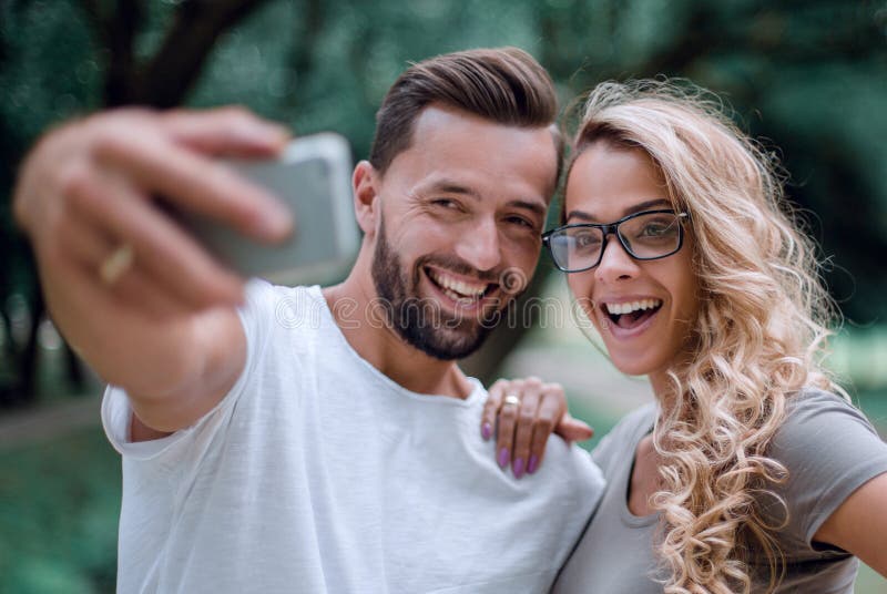 Close Up Smiling Young Couple Taking Selfie In City Park Stock Image