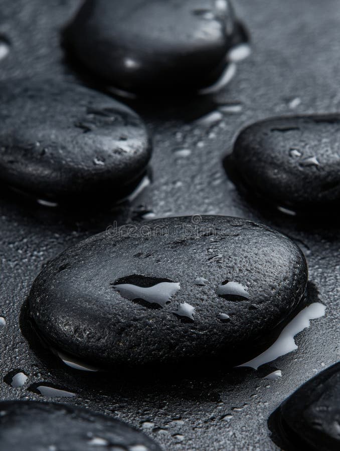 Close Up of Smooth Black River Stones on a Reflective Surface with Soft ...