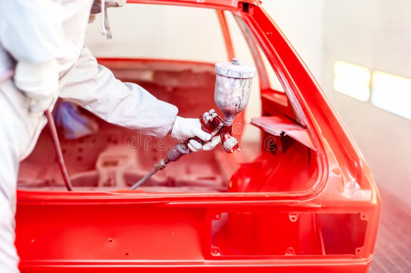 Close-up of Spray Paint Gun with Worker Working on a Red Car Stock ...