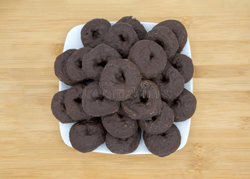 Square Plate with Round Chocolate Donuts on a Light Wood Table Stock ...