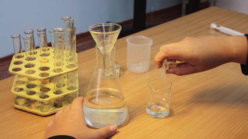 Close-up of a Student S Hands Pouring a Chemical Solution into a Flask ...