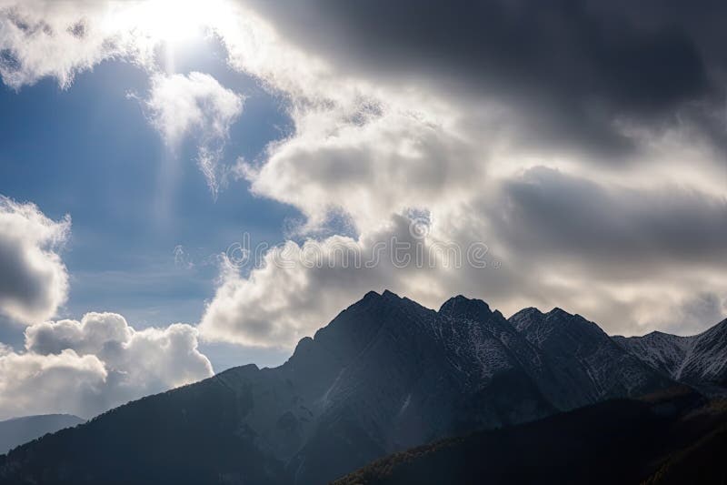 Close-up of Stunning Mountain Range with Clouds, Sun, and Blue Skies ...