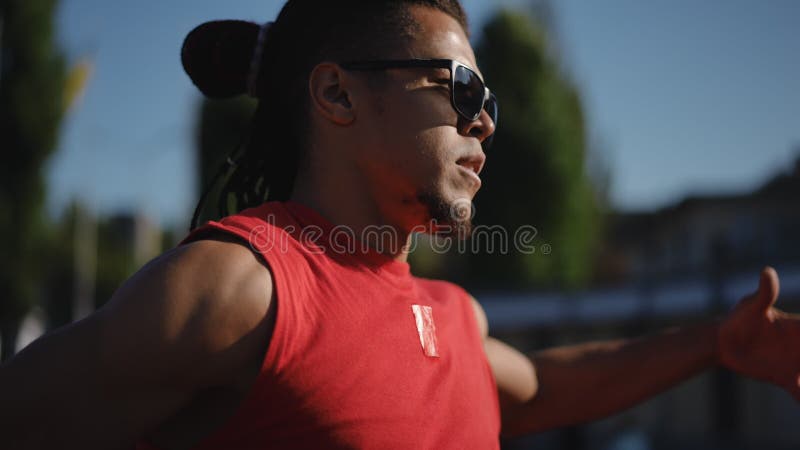 Close-up. a Stylish Athlete in Sunglasses and Dreadlocks Performs Body ...
