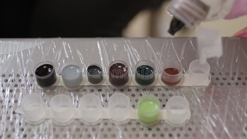Close-up of a Tattoo Master Pours Various Ink into Special Containers ...