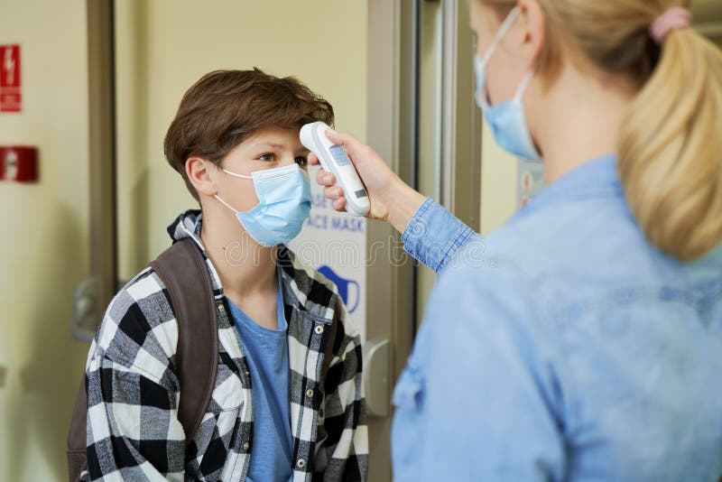 Teacher Checking the Temperature of the Students before Entering the ...
