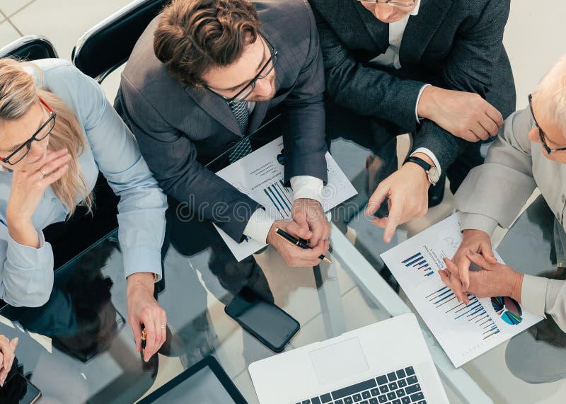 Team of Professionals Sitting at an Office Desk. Stock Image - Image of ...