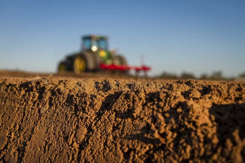 Close Up of Tilled Soil with Tractor Diffused in Background Stock Image ...