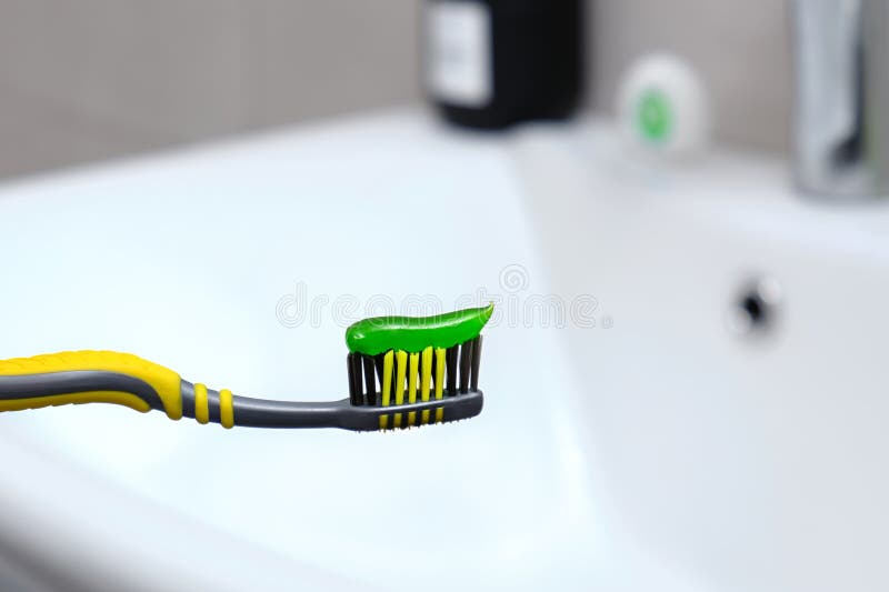 Close-up a Toothbrush with Green Toothpaste for Teeth in the Bathroom ...