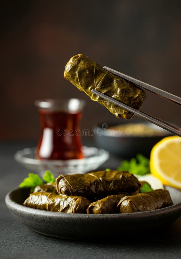 Close-up of Traditional Stuffed Grape Leaves with Lemon and Tea on Dark ...