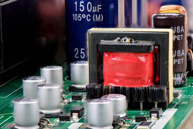 Close-up of a Transformer with Red Isolation Surrounded by Capacitors ...