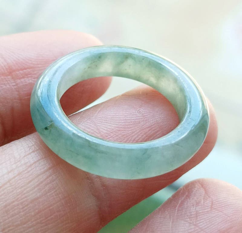 Close-Up of a Translucent Jade Ring Held between Fingers. Stock Photo ...