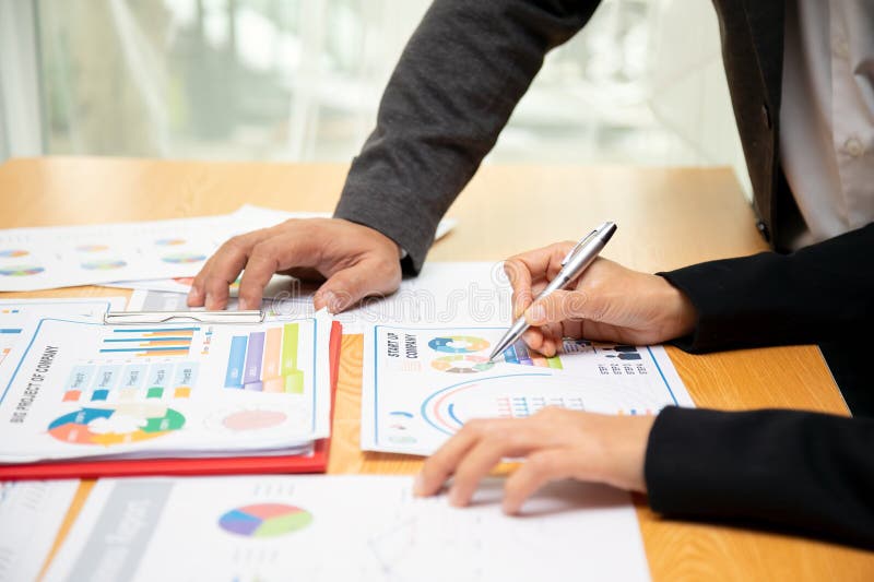 Close-up of Two Business Professionals Analyzing Project Reports and ...