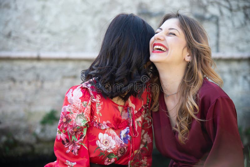 Close Up Of Two Friends A Blonde And The Other Brunette Laughing