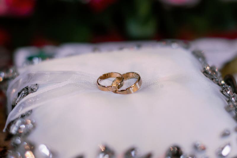 Close-up of Two Gold Wedding Rings on a Decorative Cushion, Symbolizing ...