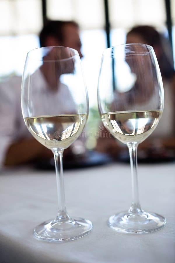 Close Up of Two Wine Glasses and Couple in Background Stock Photo ...