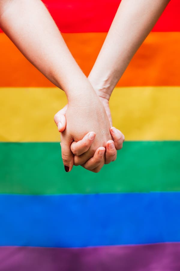Close Up Of Two Woman`s Hands Holding Each Other With The Lgbtq Rainbow