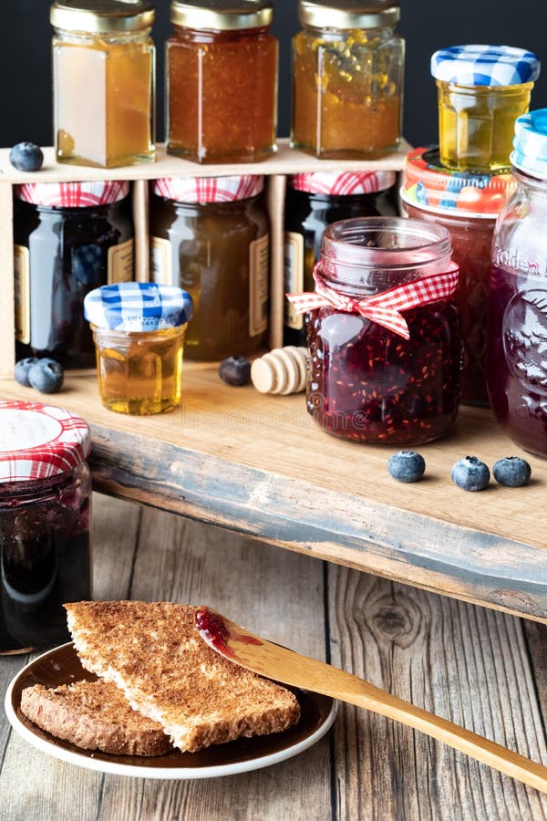 Close Up of a Variety of Different Types of Jam in Jars and Honey with ...