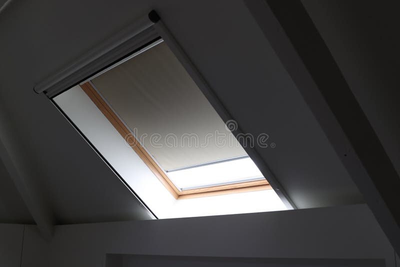 A Close Up of a Velux Skylight Window almost Closed by a Blinding. the ...