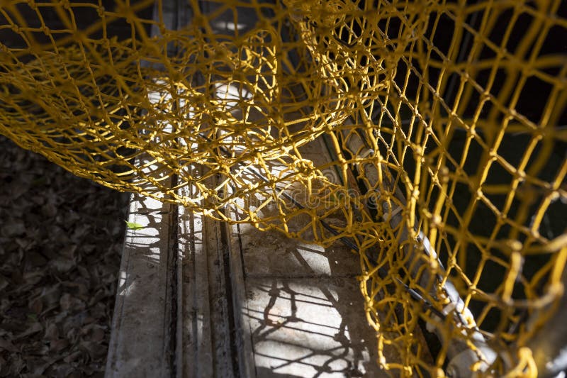 A Close-up of a Vibrant Yellow Safety Net with Shadows Cast Stock Photo ...