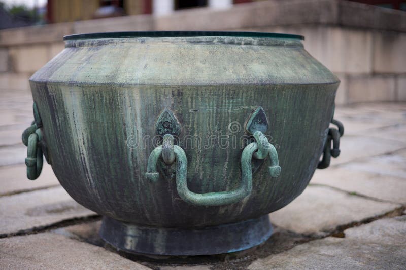 Ancient Bronze Cauldron with Intricate Handles on Stone Pavement. Stock ...