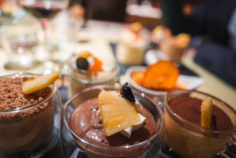 Assorted Desserts in Glass Cups with Garnishes at Dining Setting Stock ...