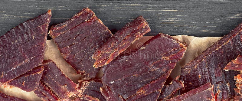 Close Up View of Beef Jerky Pieces on Wooden Table, Top View Stock ...