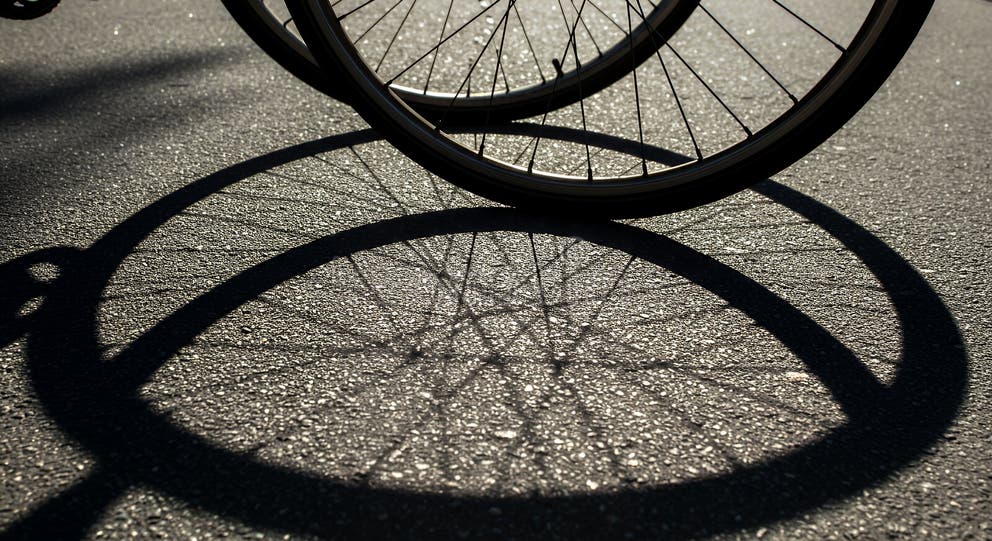 Bicycle Wheel Shadow on Asphalt Surface Creating Abstract Geometric ...