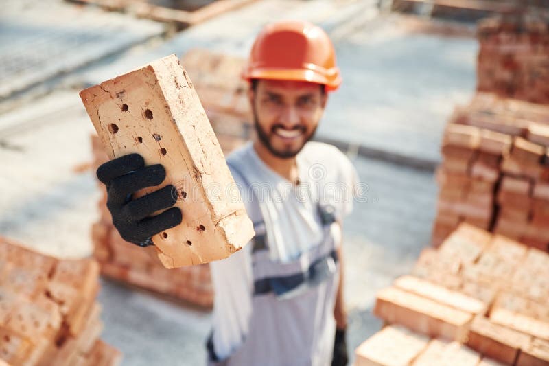 Showing and Holding Little Shovel and Brick. Handsome Indian Man is on ...