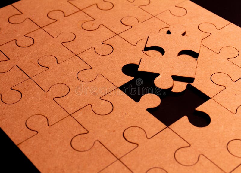 Close Up View of a Brown Puzzle with One Piece Missing Which is Near ...