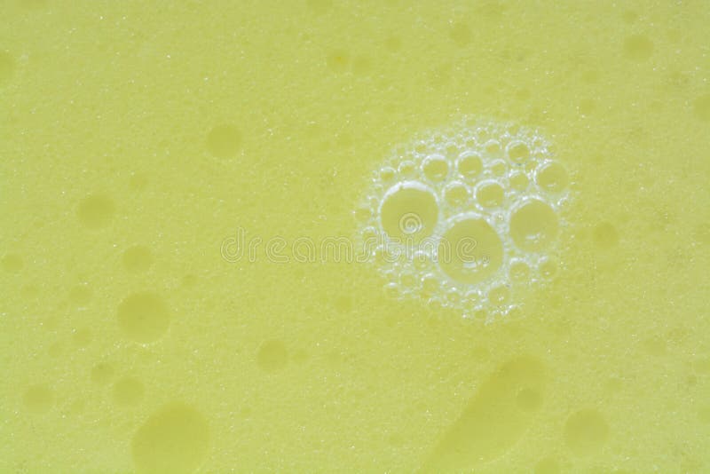 A Close-up View of Bubbles on Yellow Washing Liquid, Creating a Bubbly ...