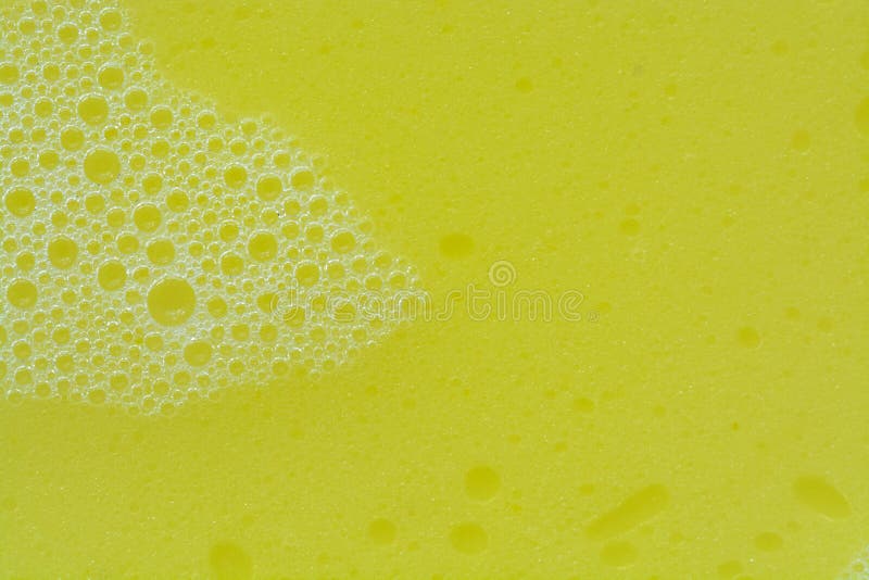A Close-up View of Bubbles on Yellow Washing Liquid, Creating a Bubbly ...