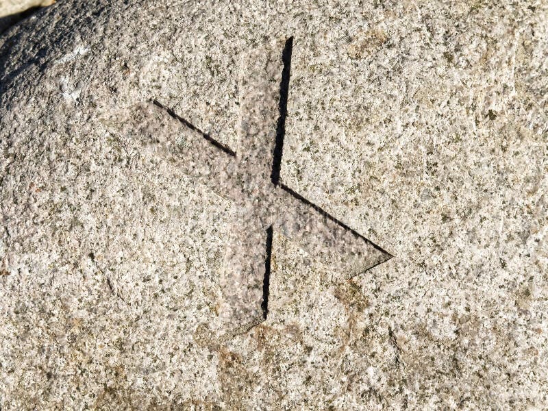 A Close-up View of a Carved Stone Featuring a Cross-like Symbol Etched ...