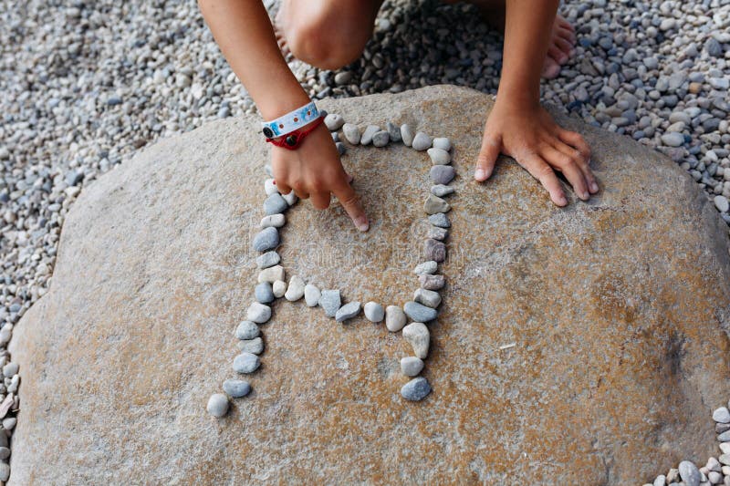 Close Up View on Child Arm and Hand Making Letter a on Big Stone Stock ...