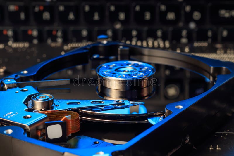 Close-up View of Disassembled Hard Drive Illuminated by Blue Light with ...