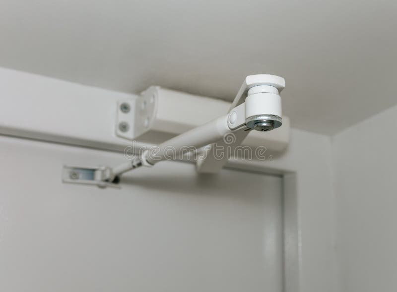 Close-up View of a Door Closer Hinge Mounted on a Metal White Door ...