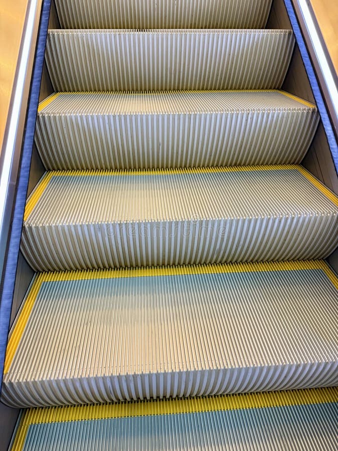 Close-up View of an Escalator with Metallic Grooved Steps and Yellow ...