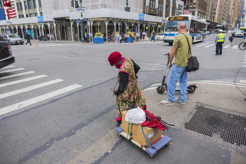 Close Up View Of Homeless Woman With Belongings On Cart Crossing Street