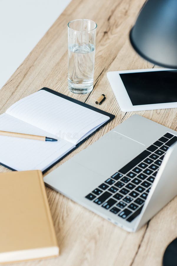 Close-up View of Laptop, Digital Tablet, Glass of Water and Notebook ...