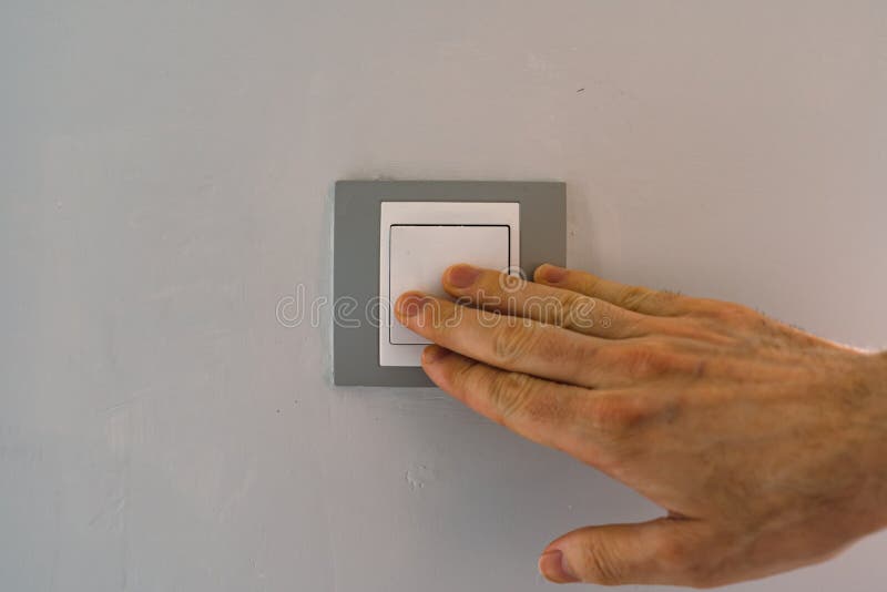 Close Up View of a Man Pressing the Light Switch of the Stay of a House ...