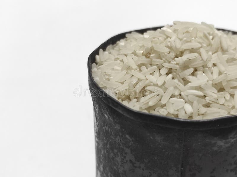 A Close-up View of a Metallic Measuring Cup Filled with White Rice, Set ...