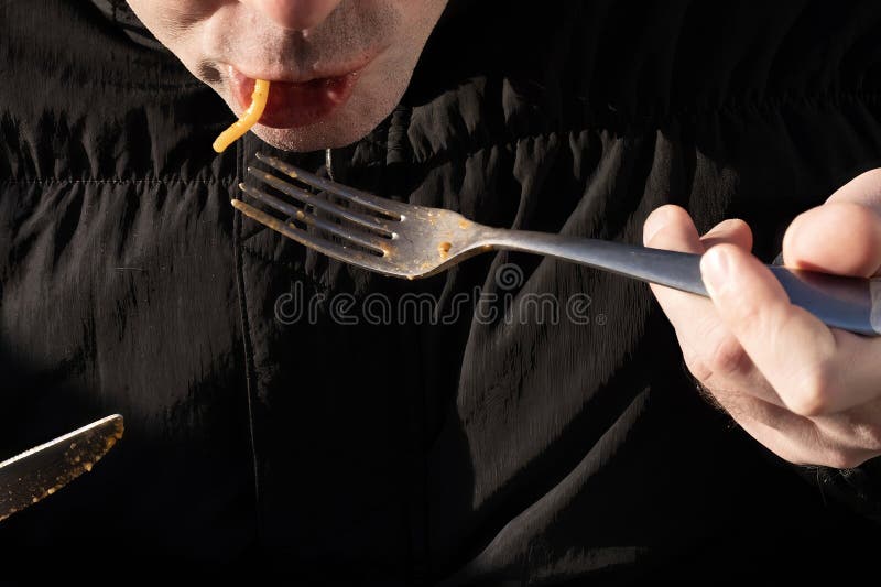 A Close-up View of a Person Eating Spaghetti with a Fork. the Focus is ...