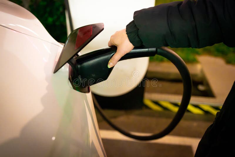 Person Plugging an Electric Car into a Charging Station Stock Photo ...