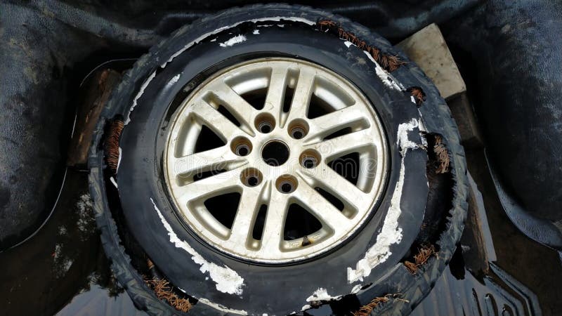 Close-up View of a Severely Damaged and Torn Car Tire on a Rough ...