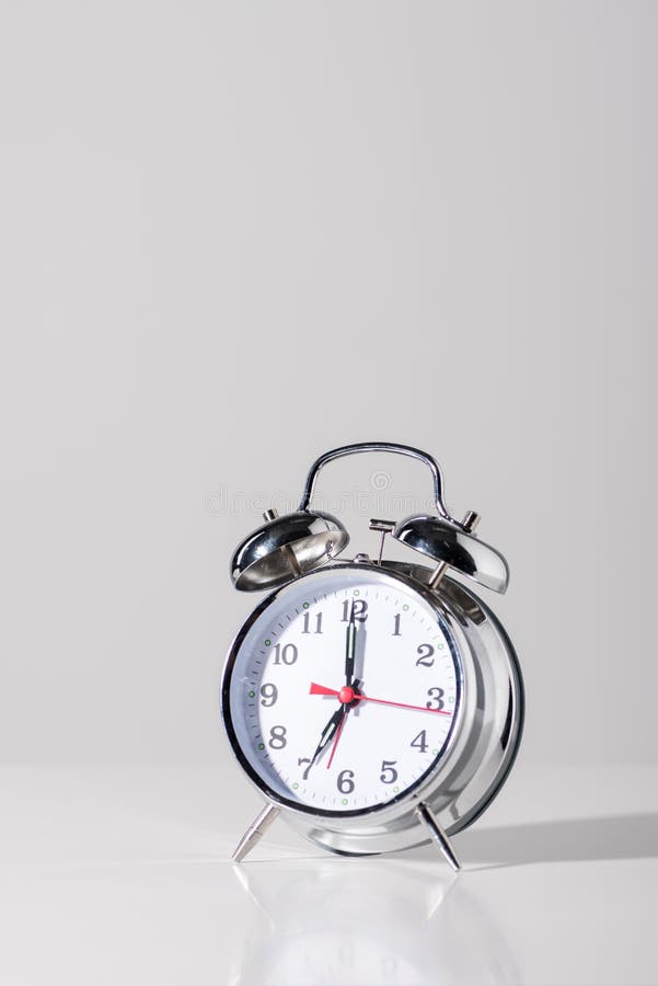 Shiny alarm clock on grey stock photo. Image of closeup - 107880140
