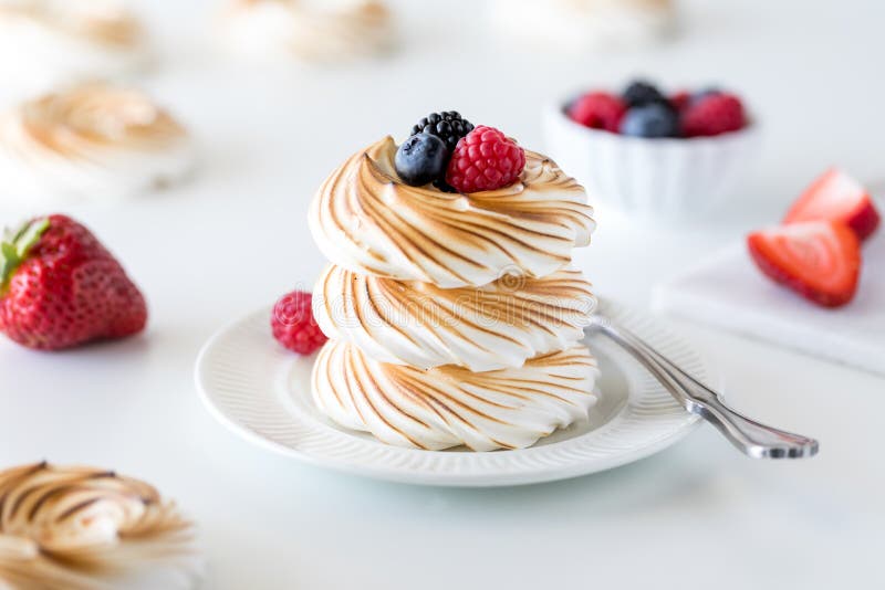 A Close Up View of a Stack of Toasted Meringues Topped with Berries ...