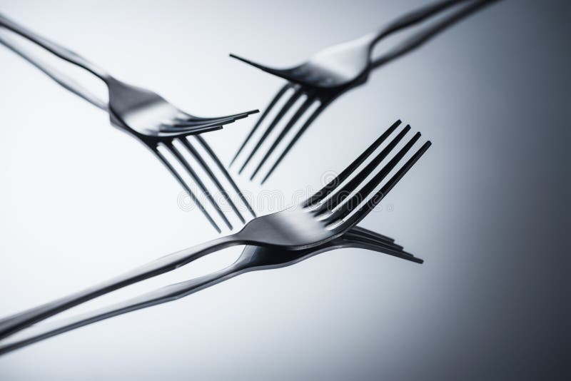 Close-up View of Three Shiny Forks Reflected on Grey Stock Image ...