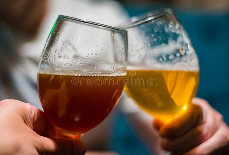 Close-up View of a Two Glass of Beer in Hand. Beer Glasses Clinking in ...