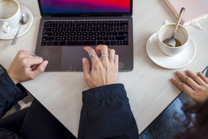 Close-up View of Two People Using a Laptop at a Coffee Shop. Stock ...
