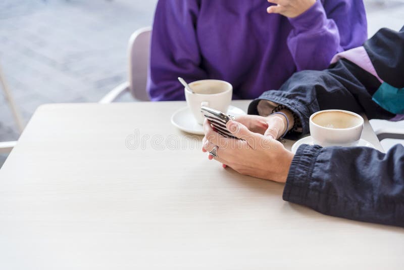 Close-up View of Two People Using Mobile Phone at a Coffee Shop. Stock ...