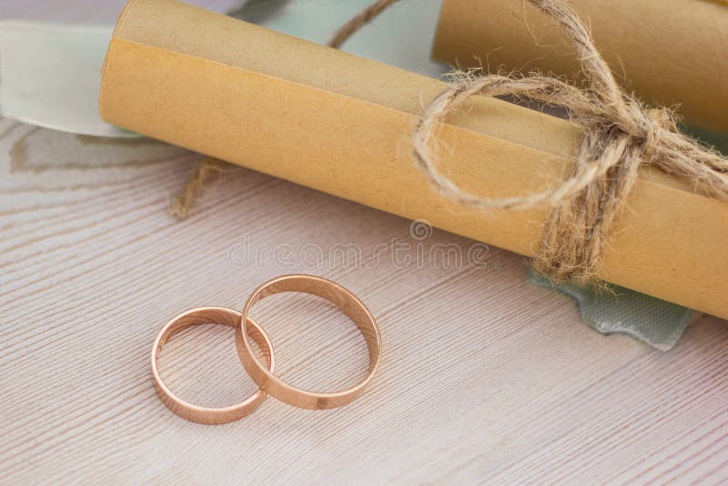 Close Up View on Wedding Rings and Two Rolled Paper Sheets with Wedding ...